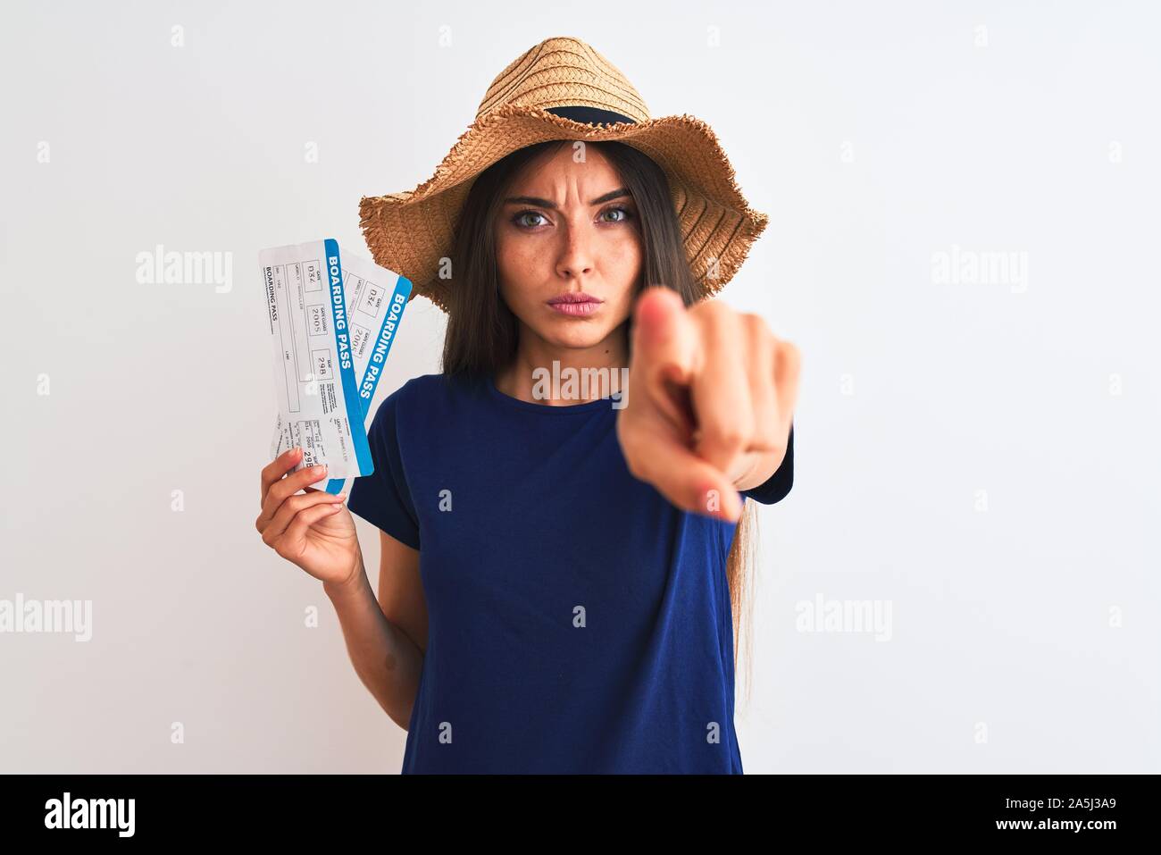 Young beautiful tourist woman holding boarding pass ticket over ...