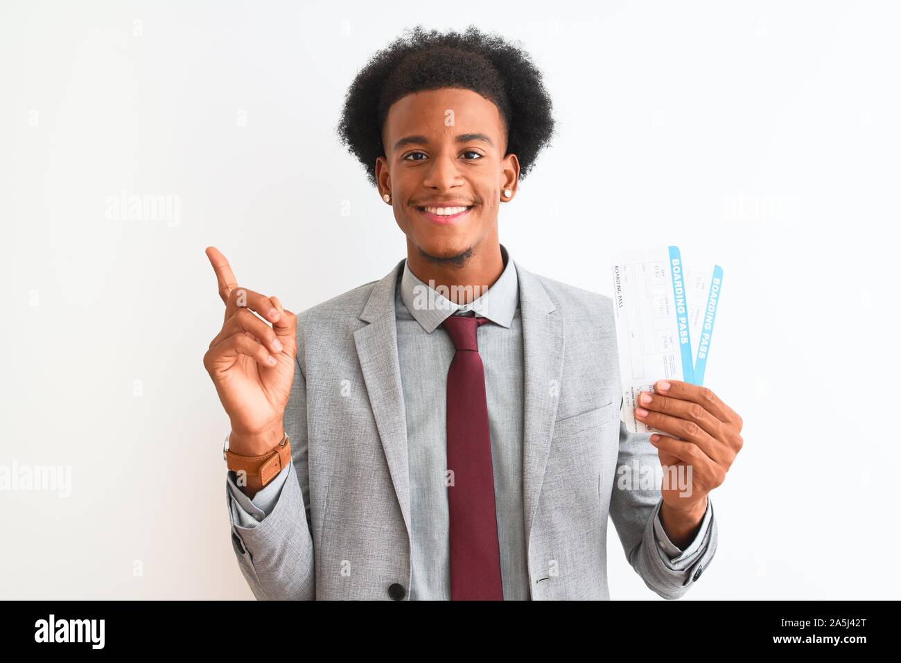 Young african american businessman holding boarding pass over isolated ...