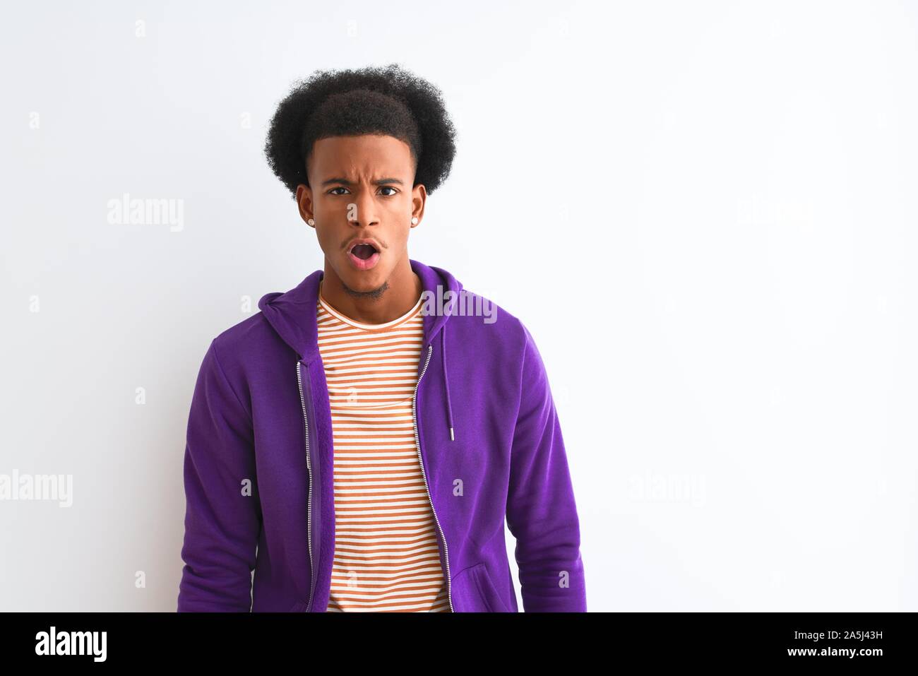 African american man wearing purple sweatshirt standing over isolated ...
