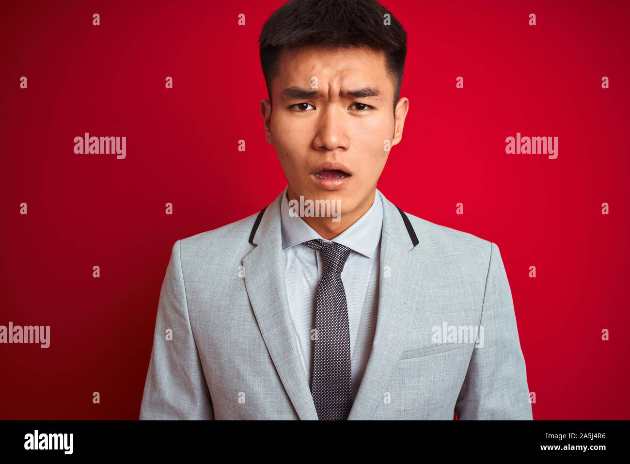 Asian chinese businessman wearing grey jacket and tie standing over ...
