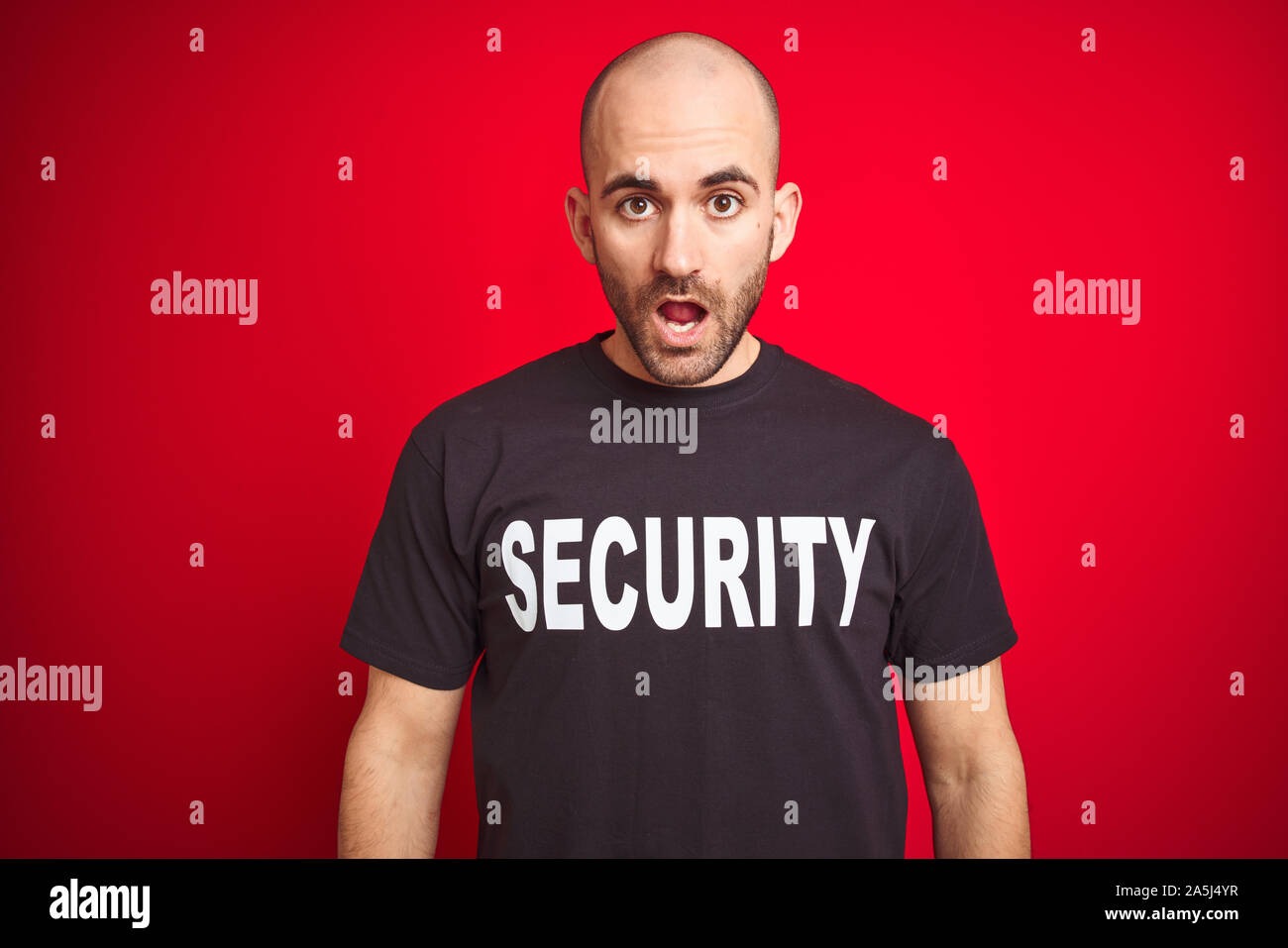 Young safeguard man wearing security uniform over red isolated ...
