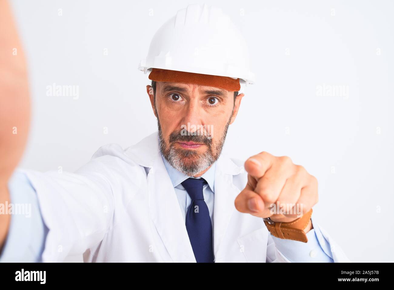 Middle age engineer man wearing helmet make selfie over isolated white ...
