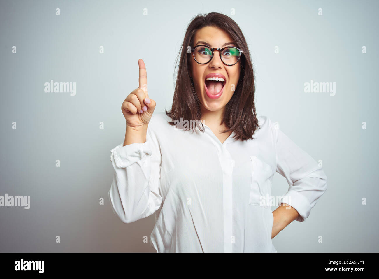Young beautiful business woman wearing glasses over isolated background ...