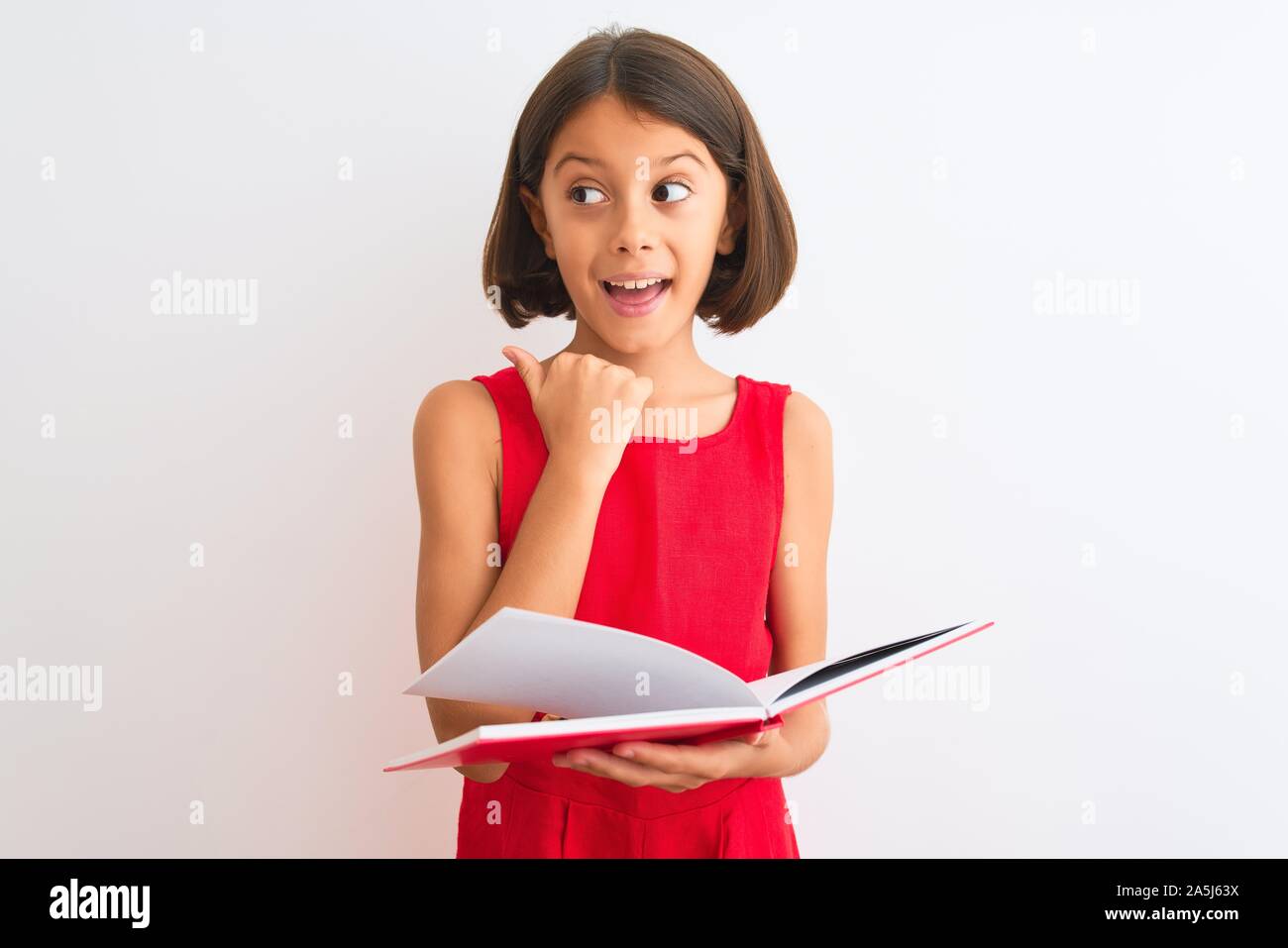 Beautiful student child girl reading red book standing over isolated ...