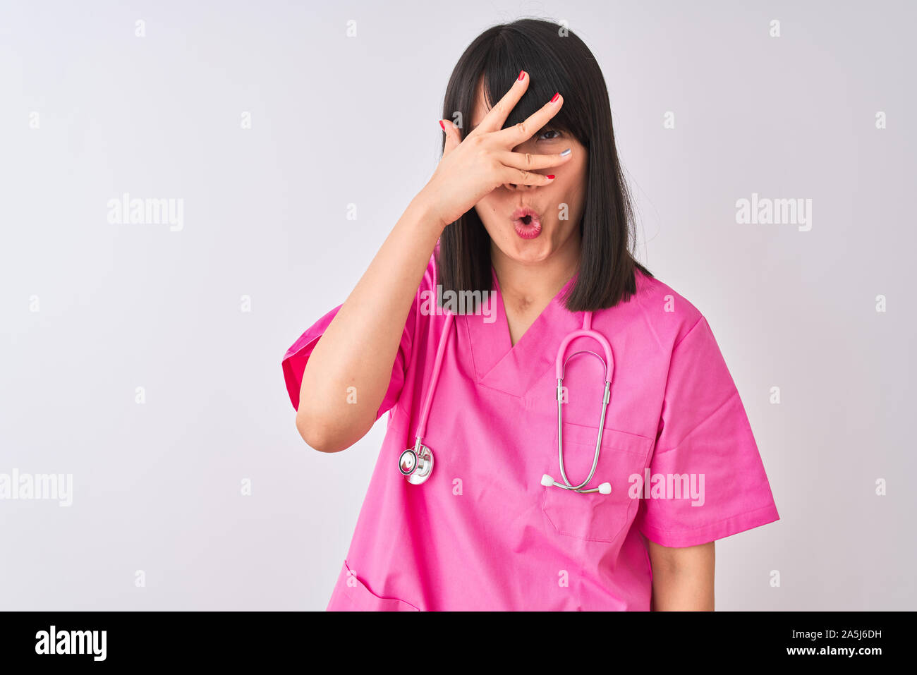 Young beautiful Chinese nurse woman wearing stethoscope over isolated ...
