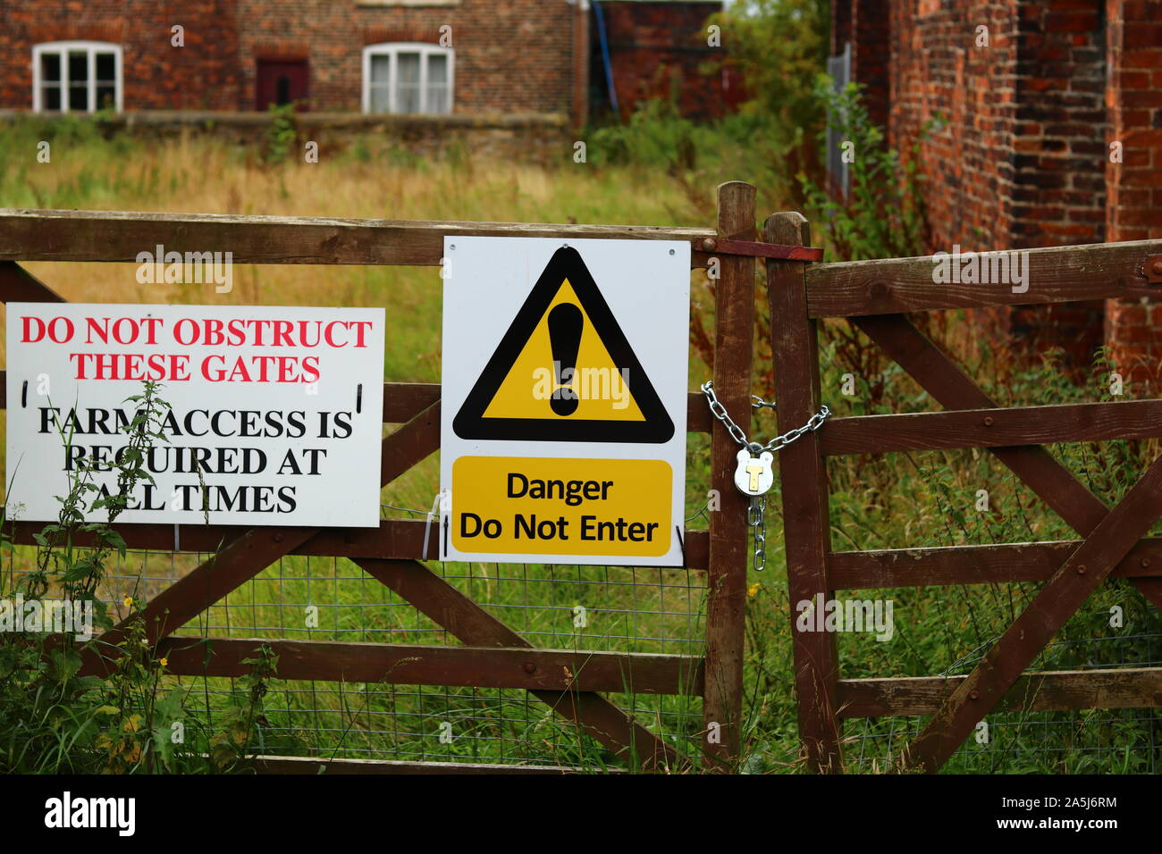 A warning sign on a farm yard gate Stock Photo - Alamy