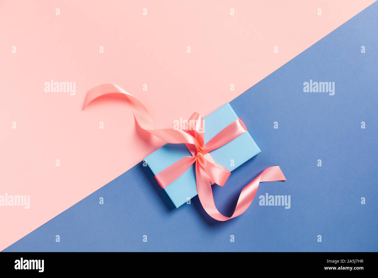 Present gift box tied up with a ribbon and a surprise inside. pink-blue ...