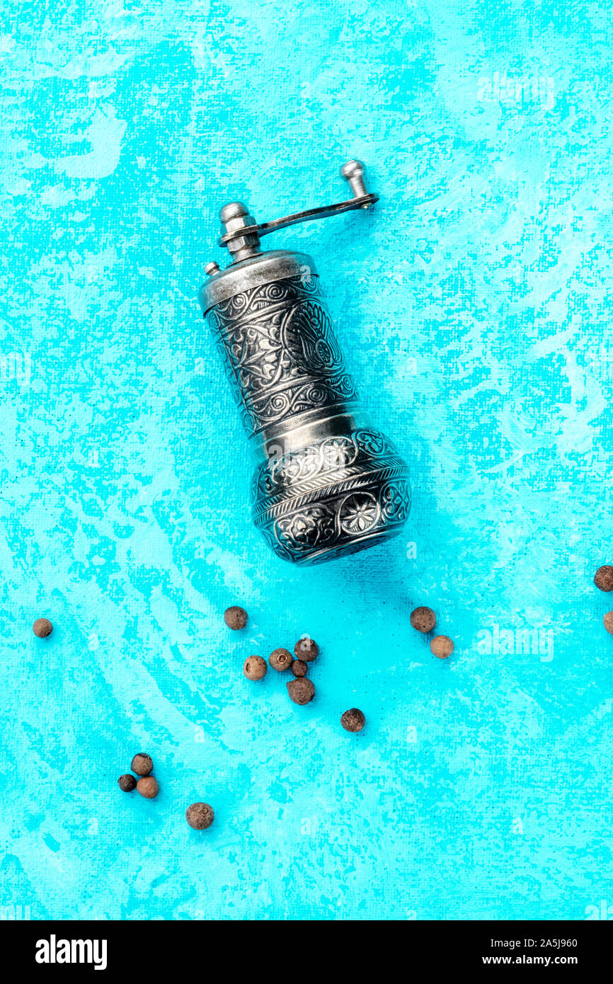 Allspice, Jamaica pepper. Black peppercorns with a vintage pepper mill ...