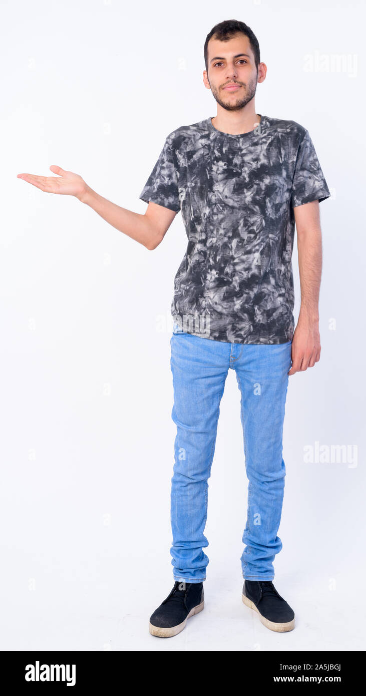 Full body shot of young bearded Persian man showing something Stock ...