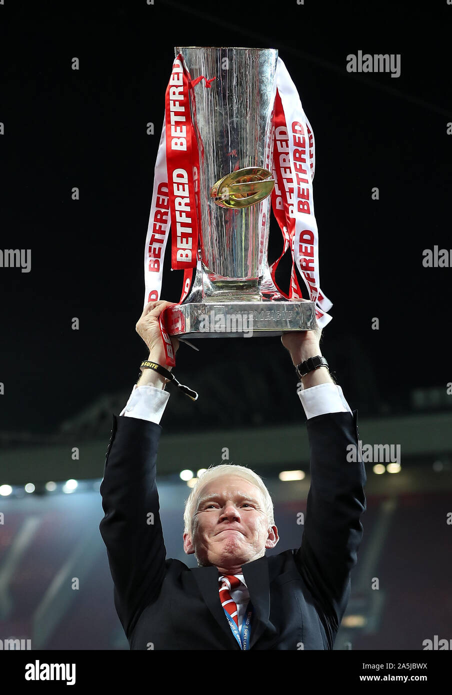 St Helens owner Eamonn McManus lifts the trophy after the final whistle ...