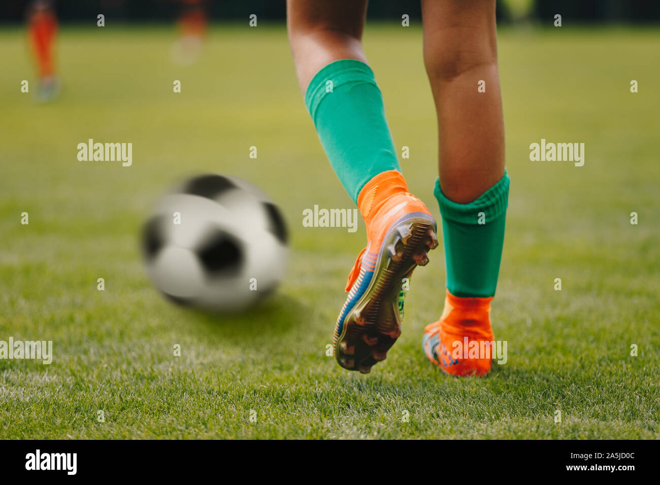 Single soccer football player standing next to ball ready to kick. Legs ...