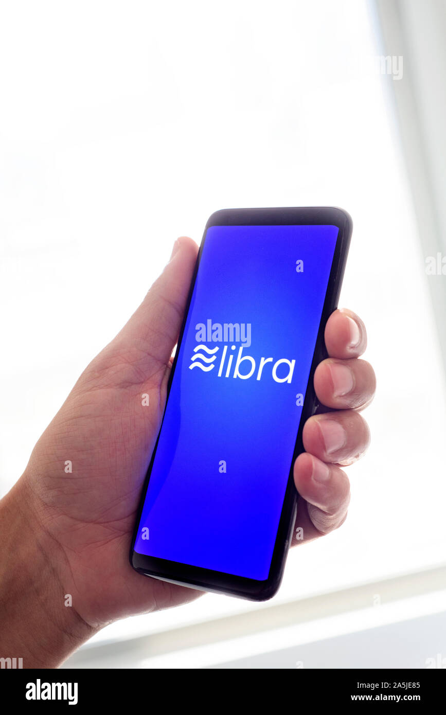BARCELONA, SPAIN - JUNE 20, 2019: A young caucasian man uses a smartphone, with the logo of ...