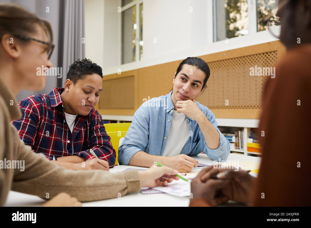 Multi-ethnic group of students discussing group project and ...