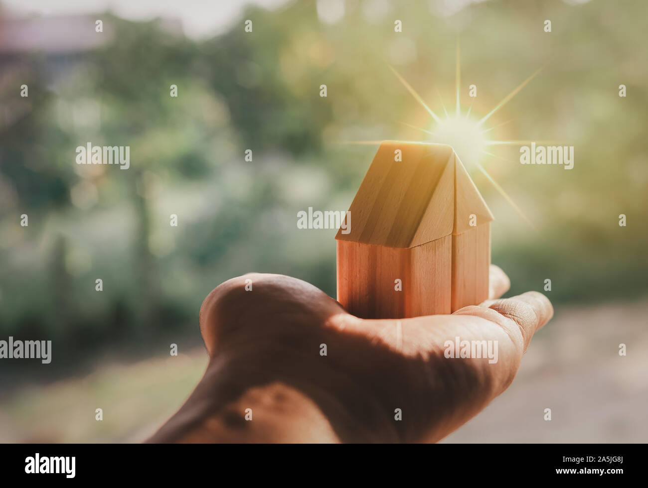 house from wooden block in human plam with blur background Stock Photo ...