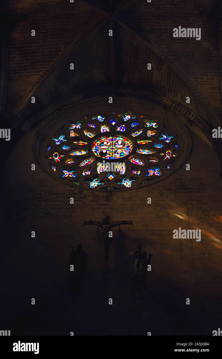 Stained glass window in the Sevilla Cathedral. Crucifix. Light and ...