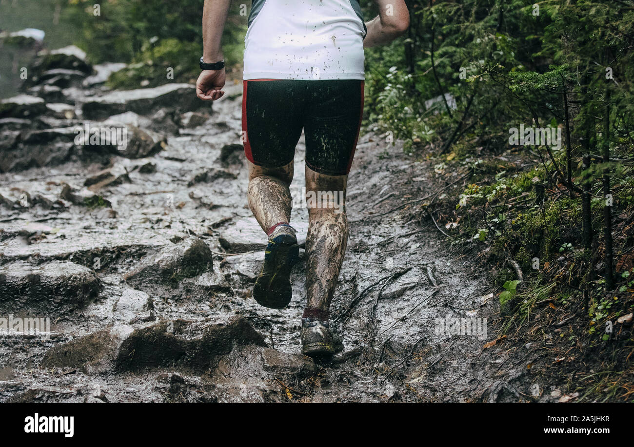 back man runner run autumn mountain trail through mud and water Stock ...