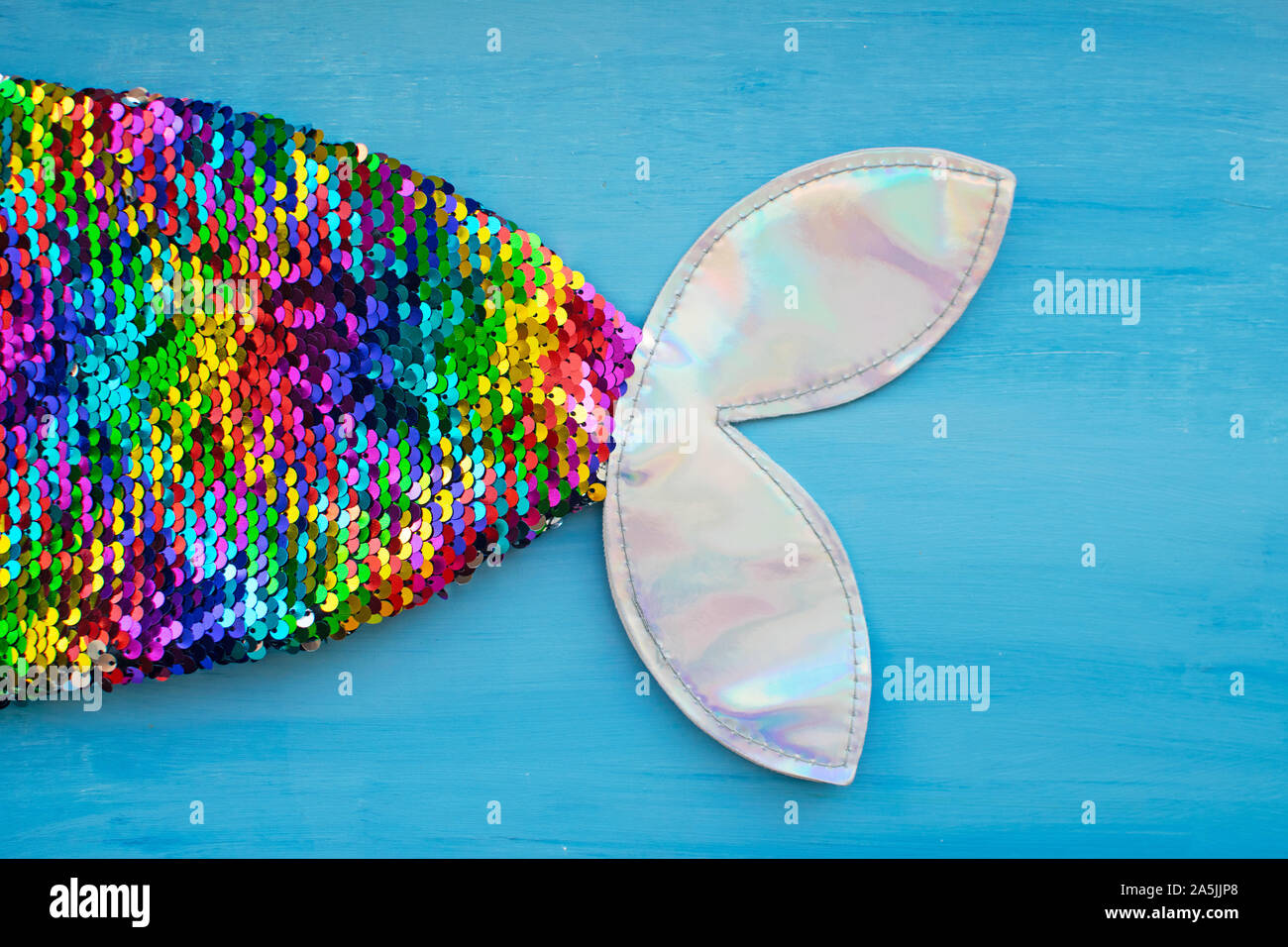 Bright rainbow mermaid tail on a blue background Stock Photo - Alamy