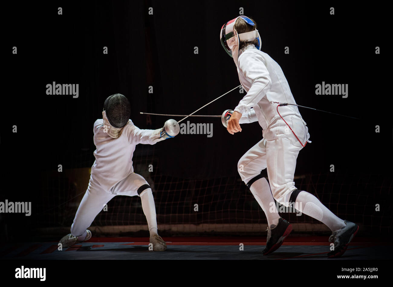 Two fencing athletes fight on professional sports arena Stock Photo - Alamy