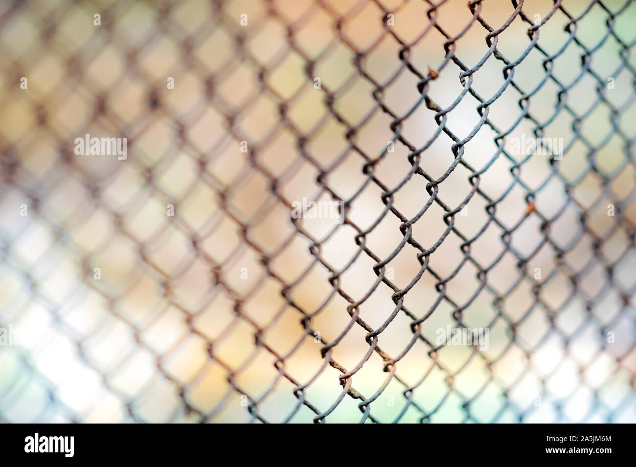 Old rusty mesh fence. Blurred colorful background Stock Photo - Alamy