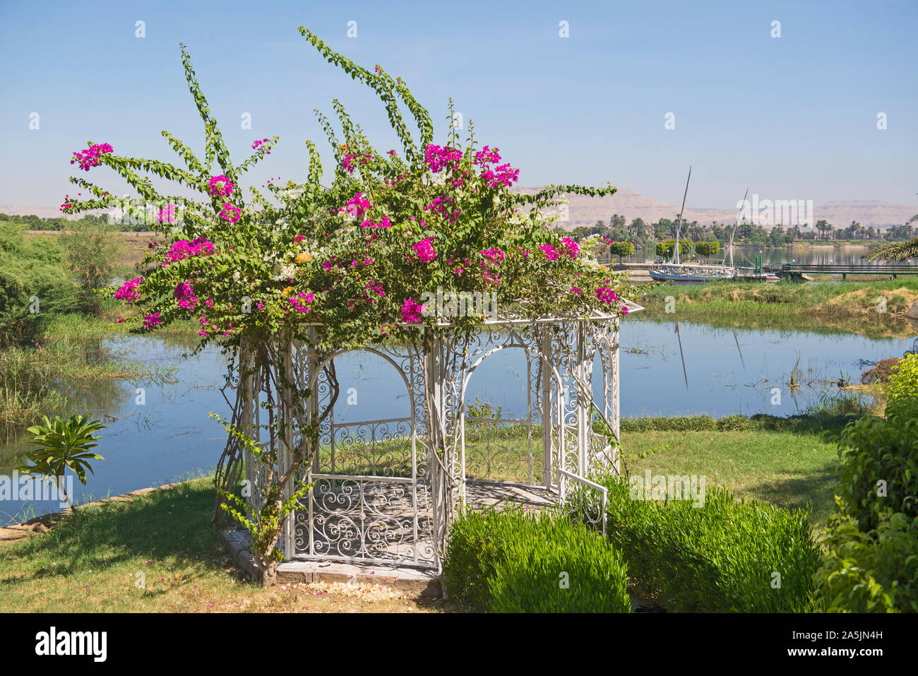Steel metal pagoda pavilion in formal rural garden setting on flooded ...