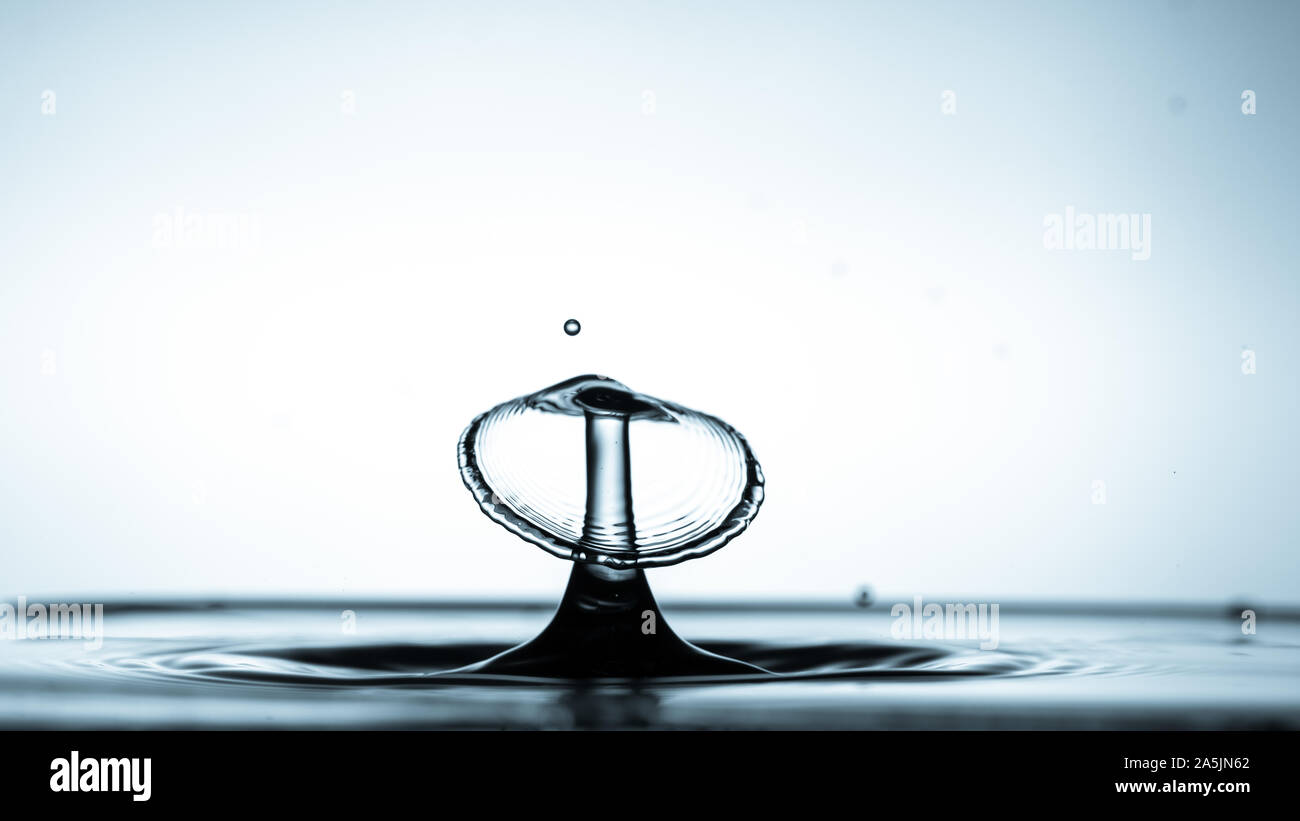 Close-up of a water drop falling on water surface Stock Photo - Alamy