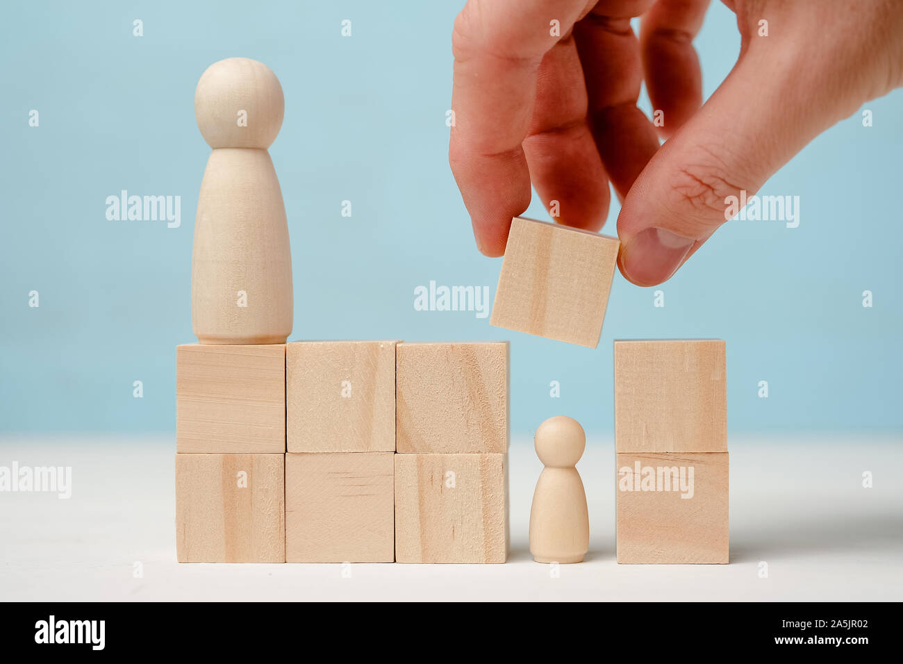 Male hand closes small wooden figure by blocks under the supervision of ...