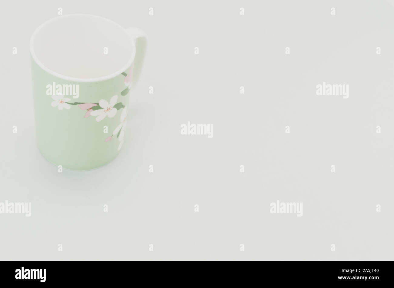 empty modern white decorated green mug on a blank surface - directly ...