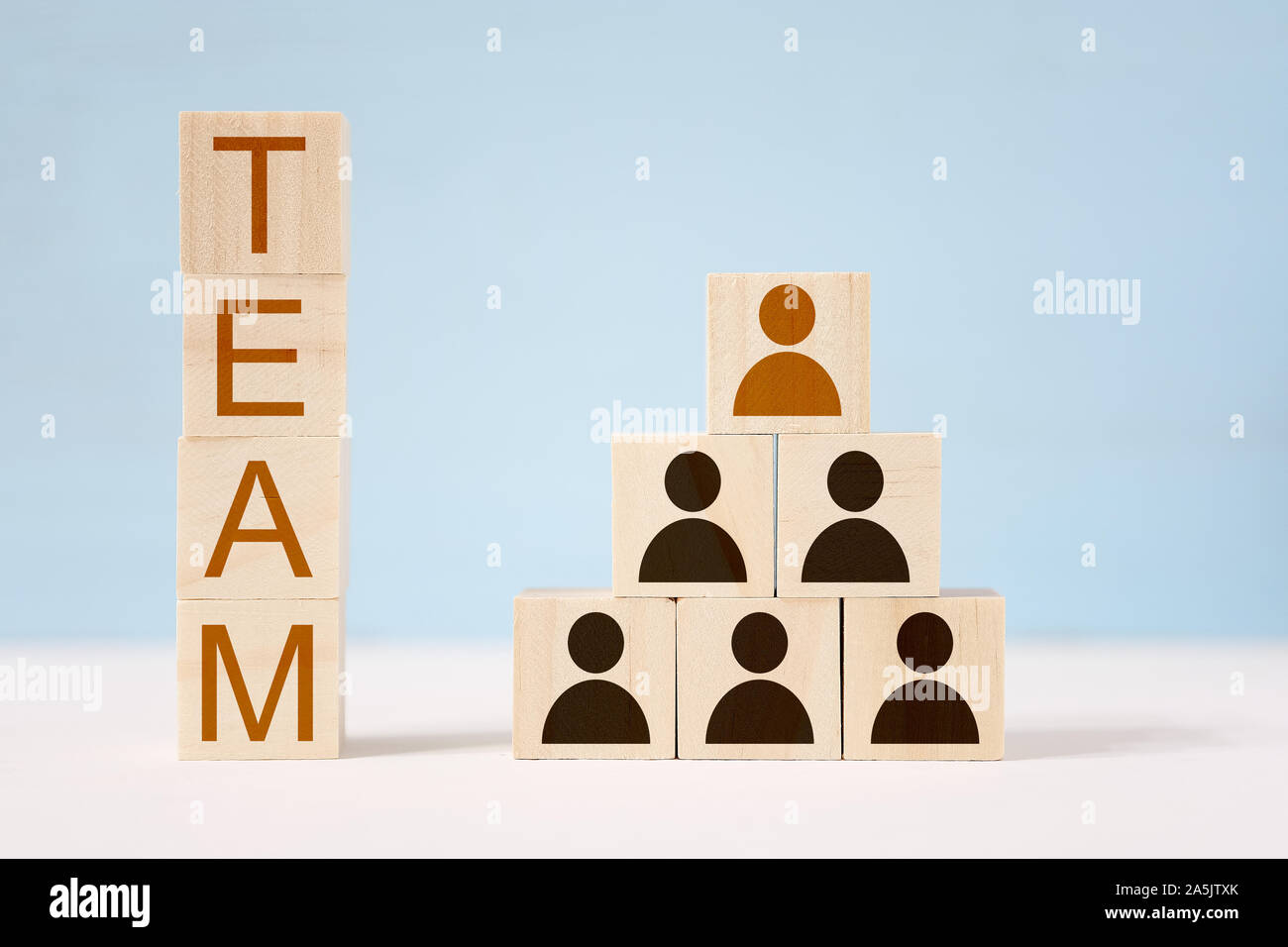 Wooden toy cubes with painted men in hierarchical order and inscription ...