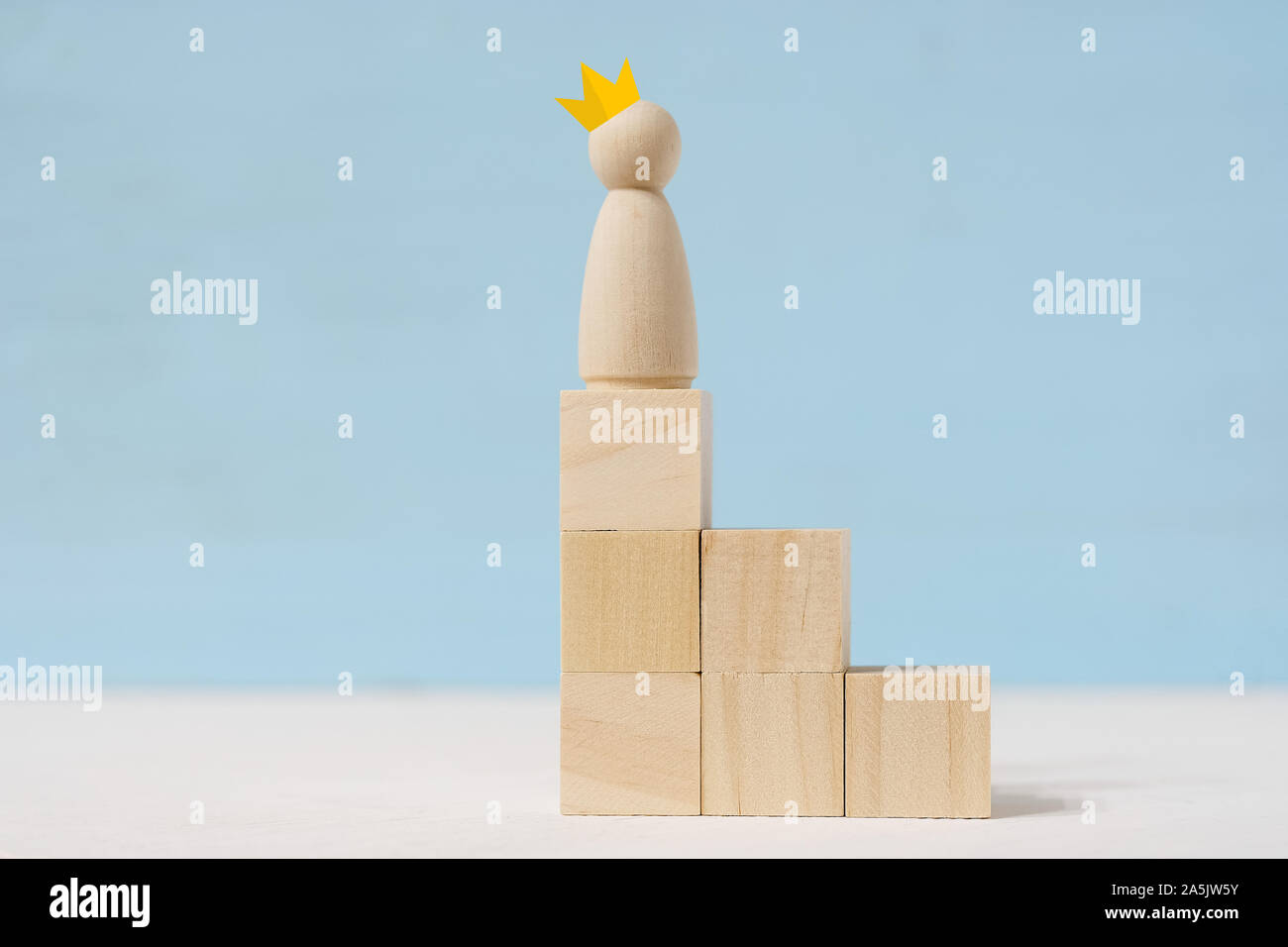 Abstract wooden faceless figure of man with painted crown on upper ...