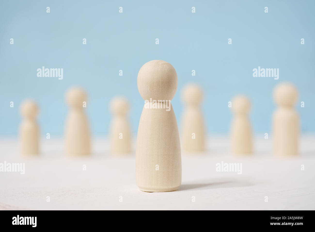 Abstract wooden figures of man and people stand apart from each other ...