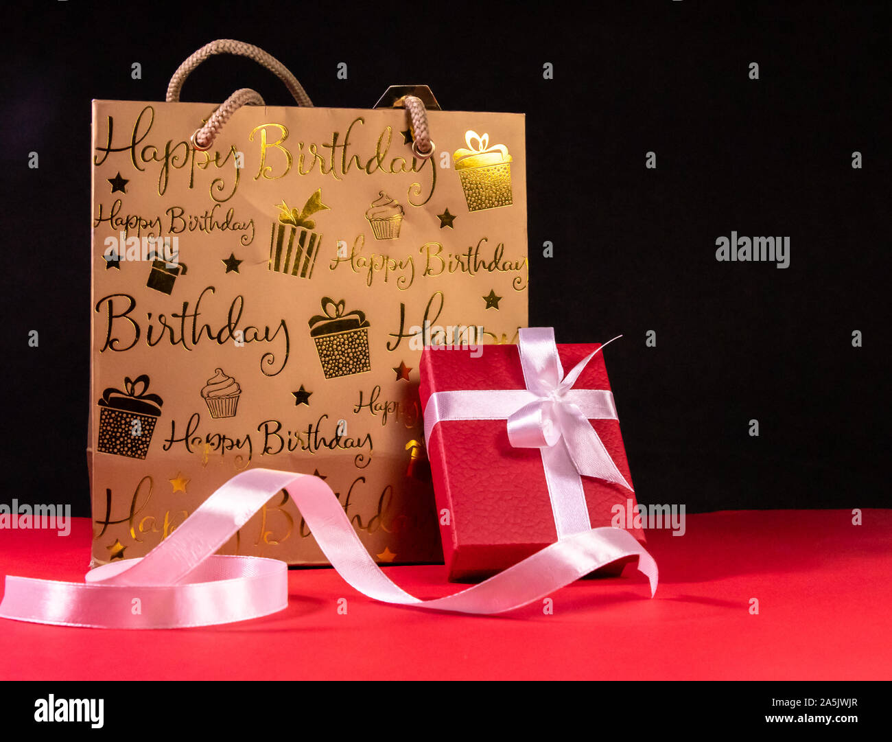 Red gift box with white ribbon and birthday carry bag for mother on red ...
