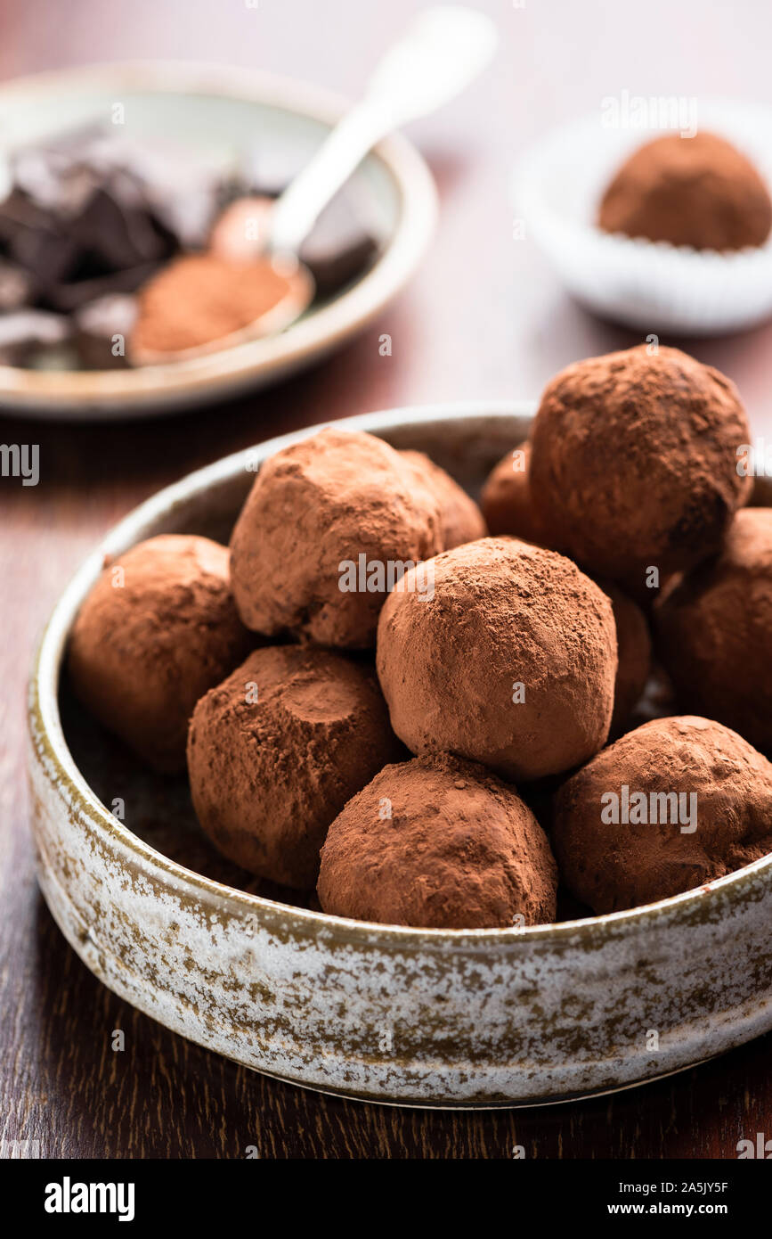 Chocolate truffle candy coated in cocoa powder against black background ...