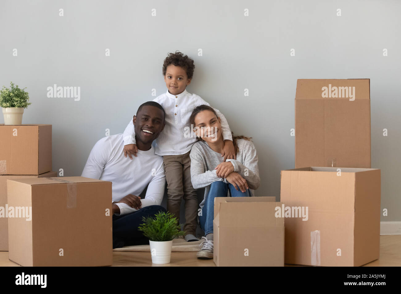 Happy multiracial young family moving to new home together Stock Photo ...