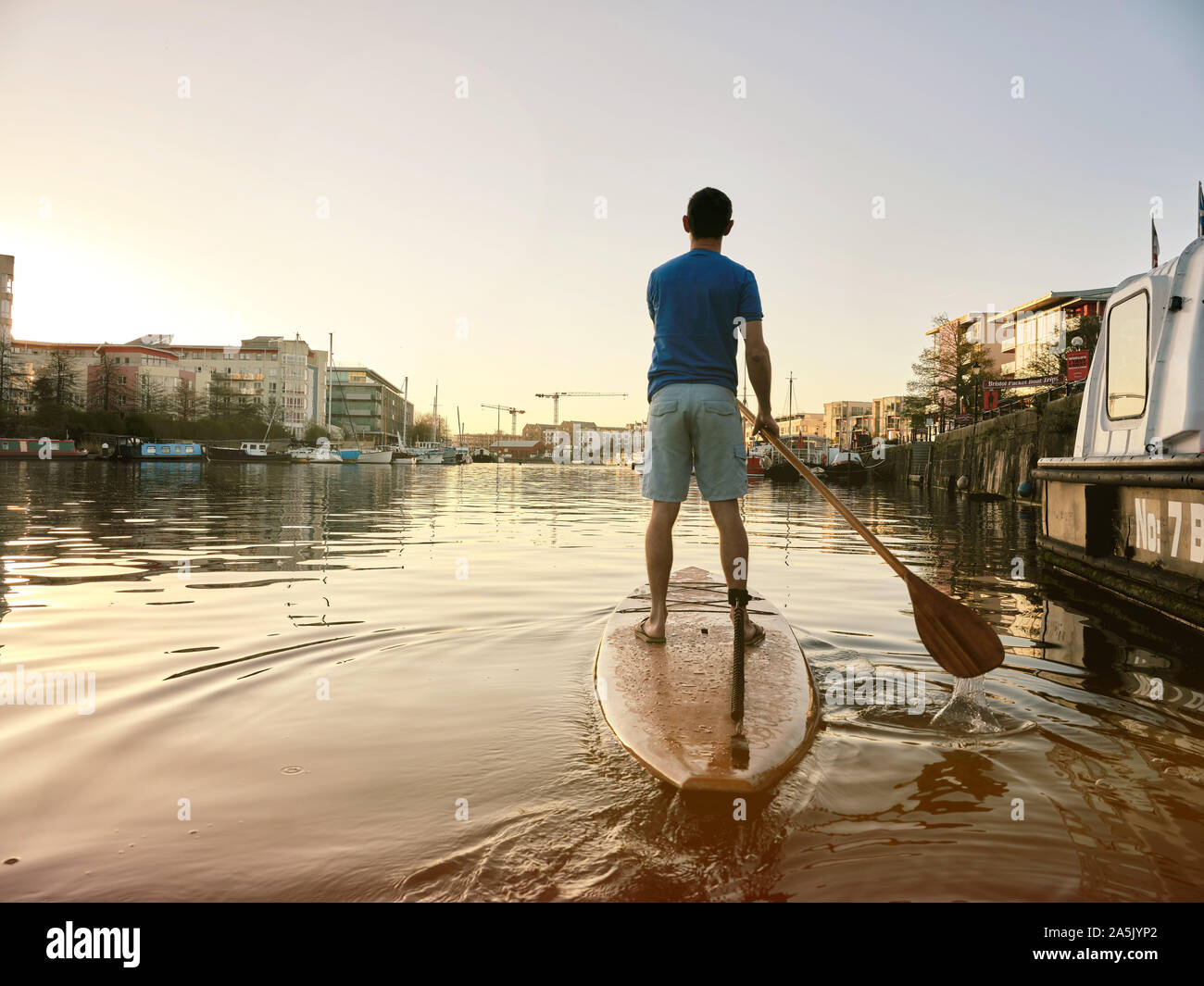 Rear view man paddleboarding hi-res stock photography and images - Alamy