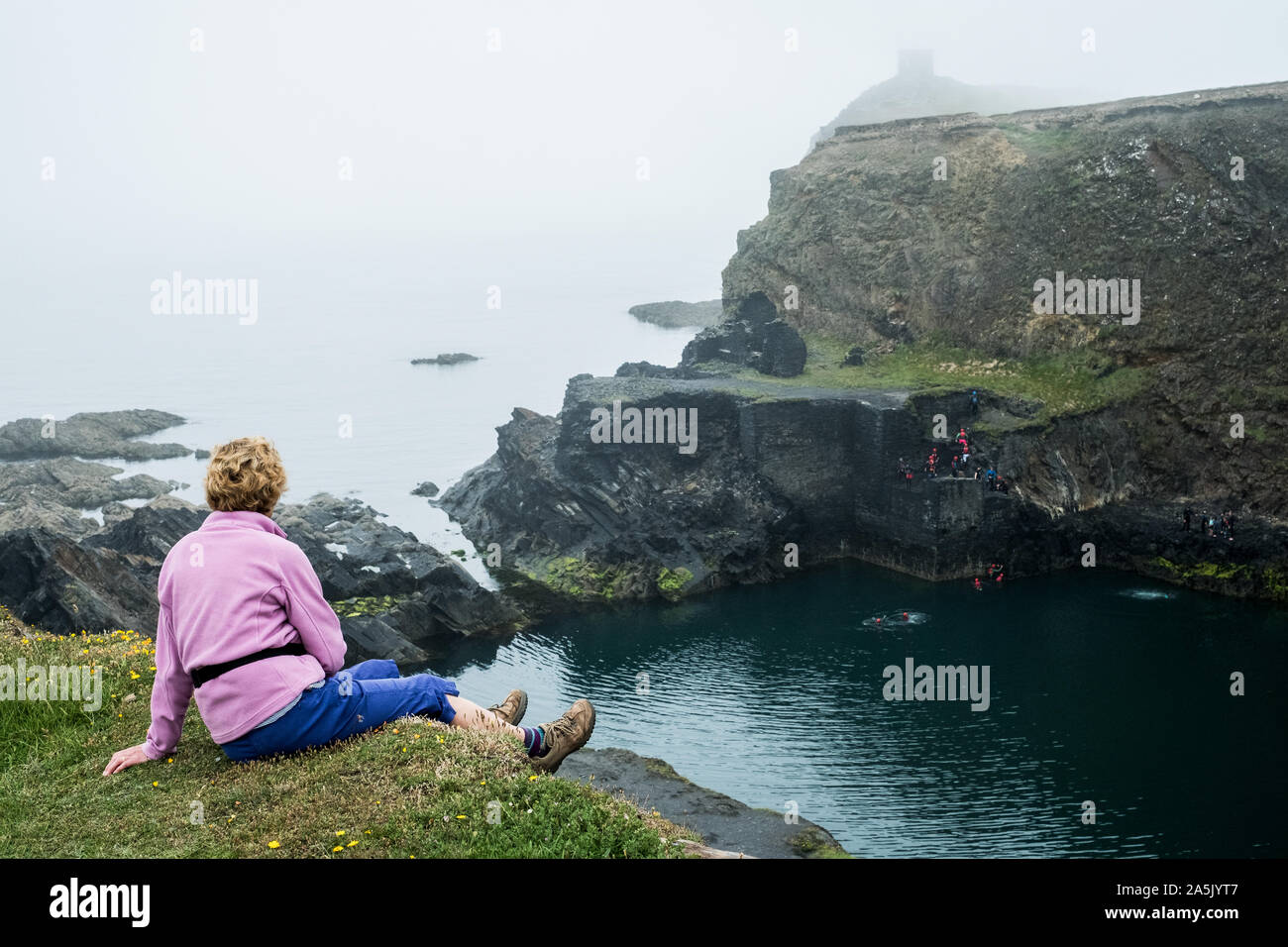 Woman sitting on top cliff hi-res stock photography and images - Alamy