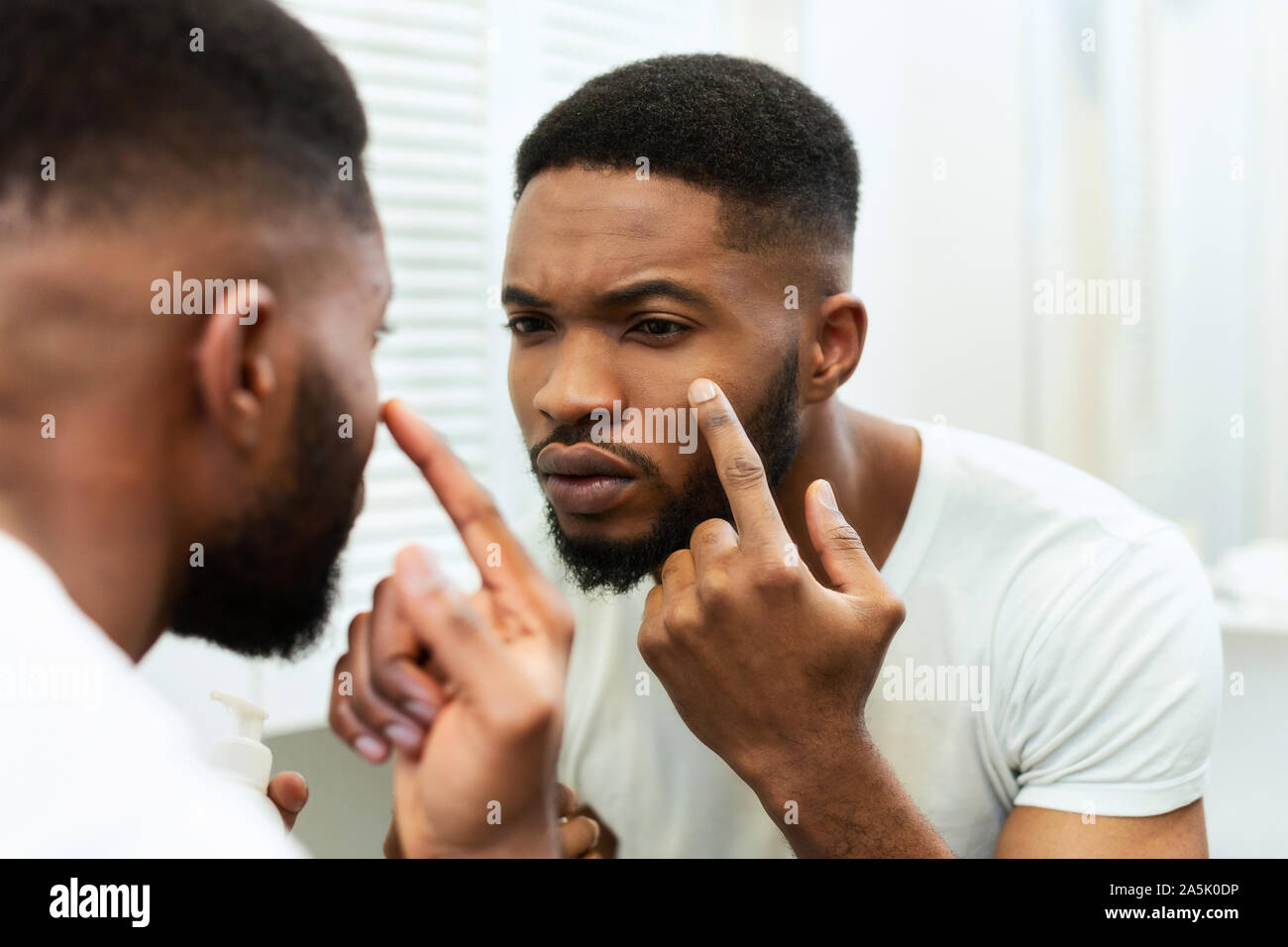 Young african man touching face, examining quality skin Stock Photo - Alamy