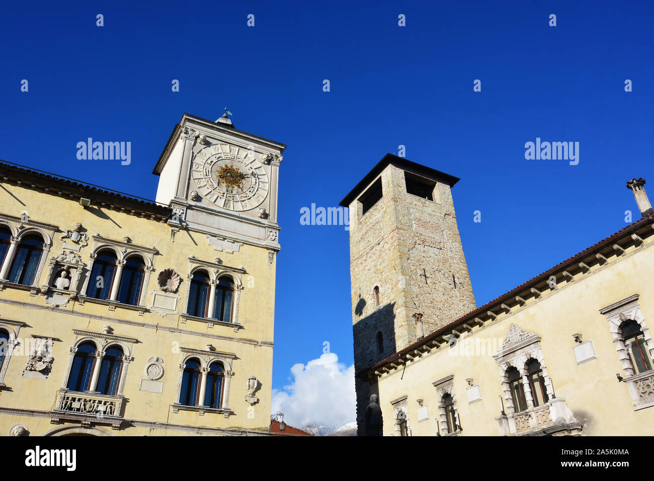 the town hall and the clock tower in the city center of Belluno, Italy ...
