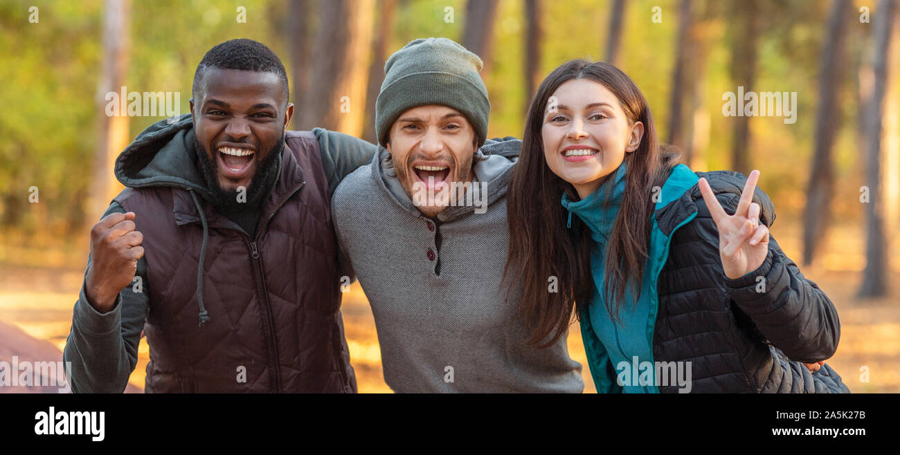 Portrait of excited group of tourists posing over forest background ...