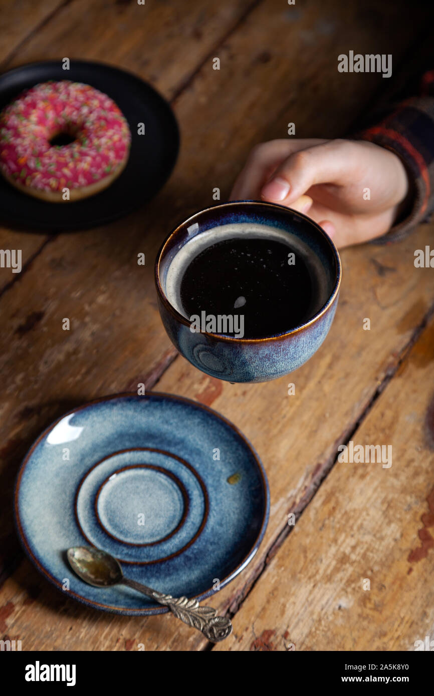 Tasty strawberry sprinkled donut, vintage tea spoon, black americano ...