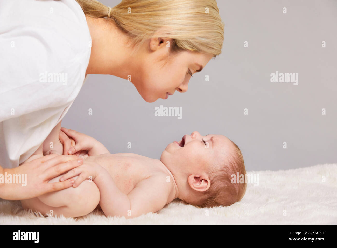 Mother gently calming crying baby boy Stock Photo - Alamy