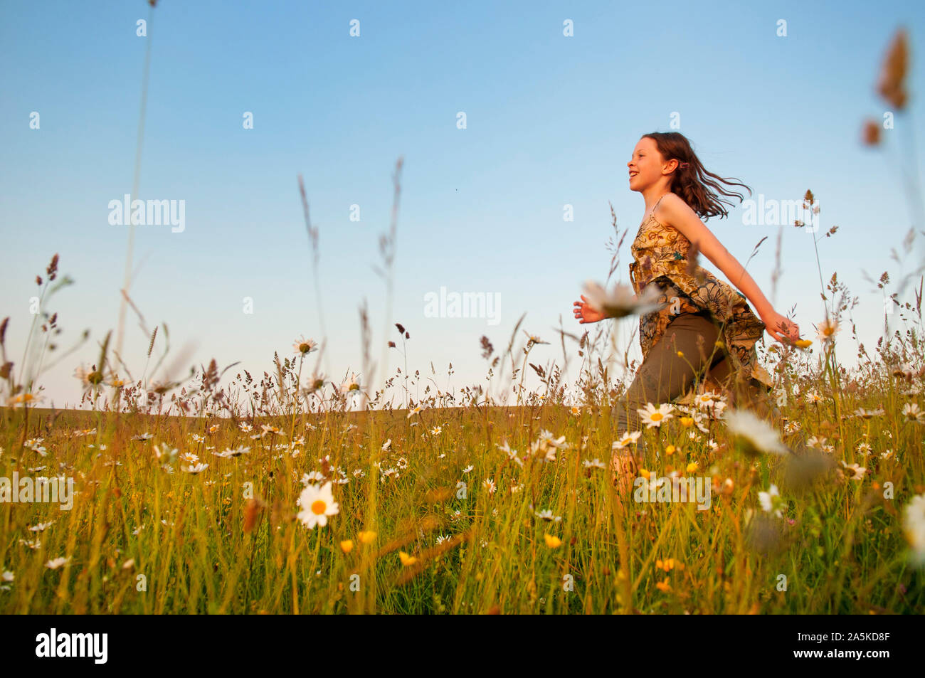 Girl running through field wearing hi-res stock photography and images ...