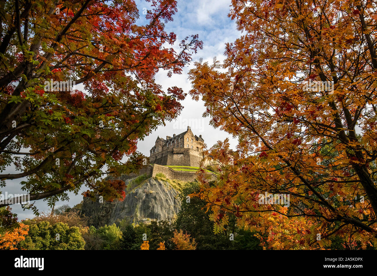 Edinburgh Castle is framed by trees displaying their autumn colours in ...