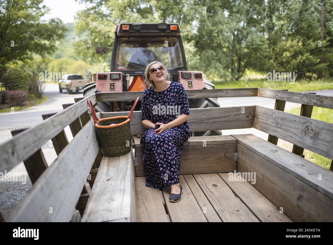 The mid aged woman is riding a tractor trailer in the countryside Stock ...