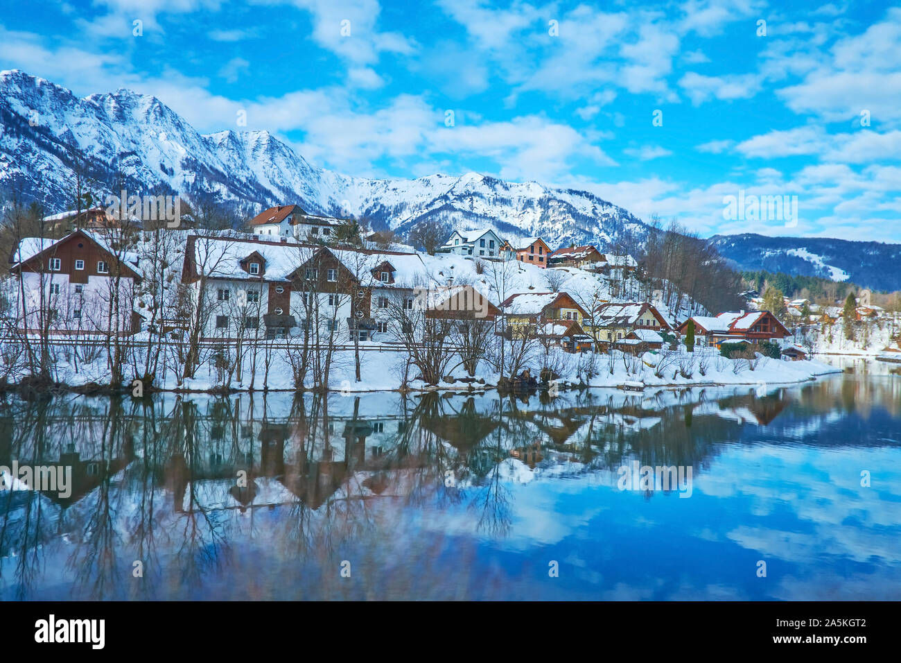 The snowbound housing of Bad Goisern is reflected on mirror surface of ...