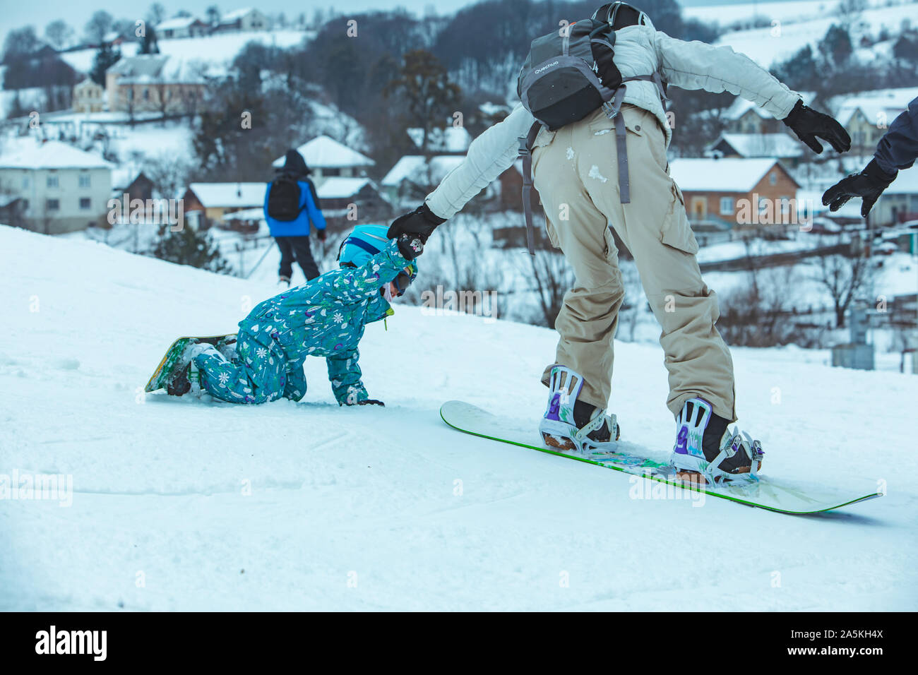 mother teaching little girl to snowboarding Stock Photo - Alamy