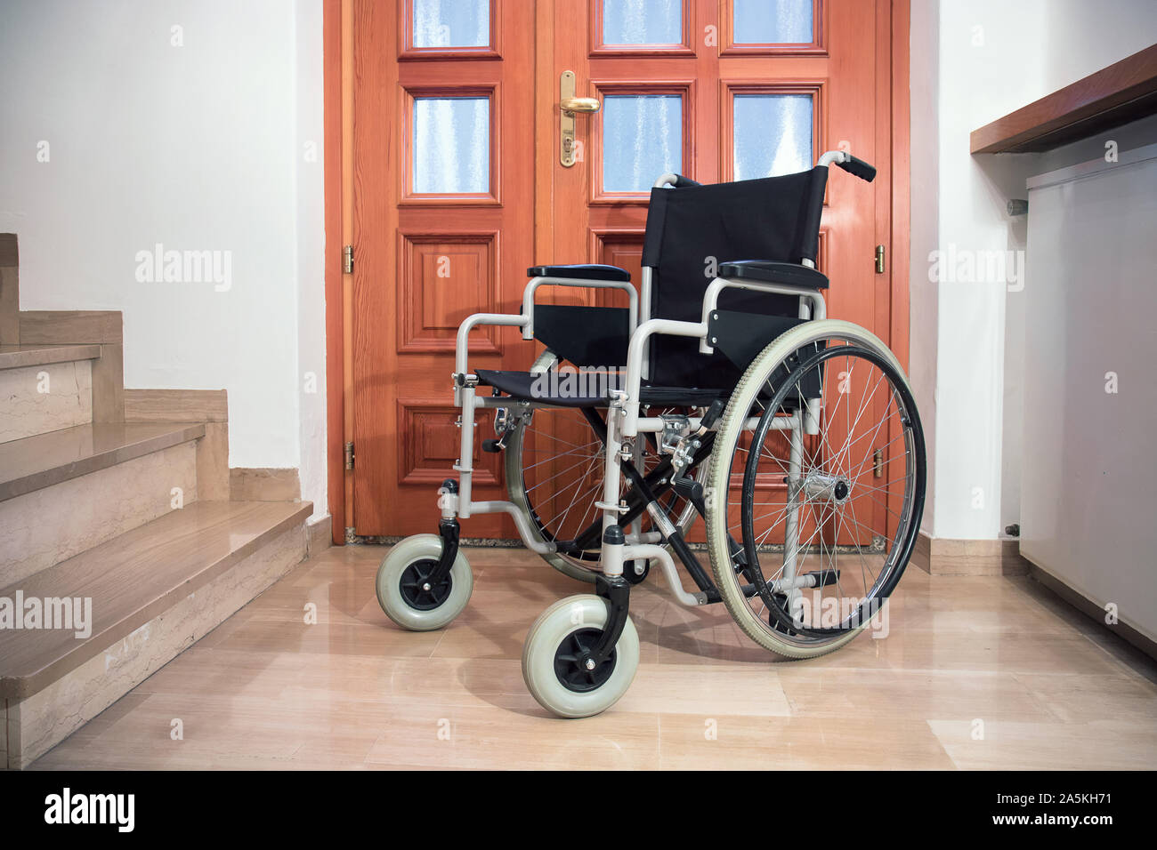 empty wheelchair at home, object symbol of disability near the stairs ...