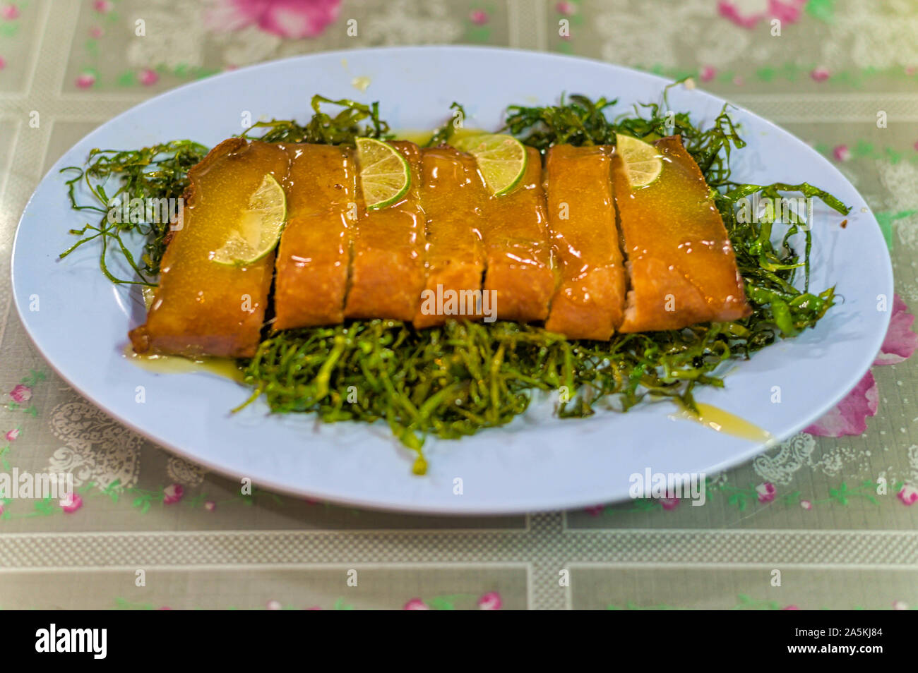 Fried pork topped with lemon sauce and lemon pieces, with shredded ...