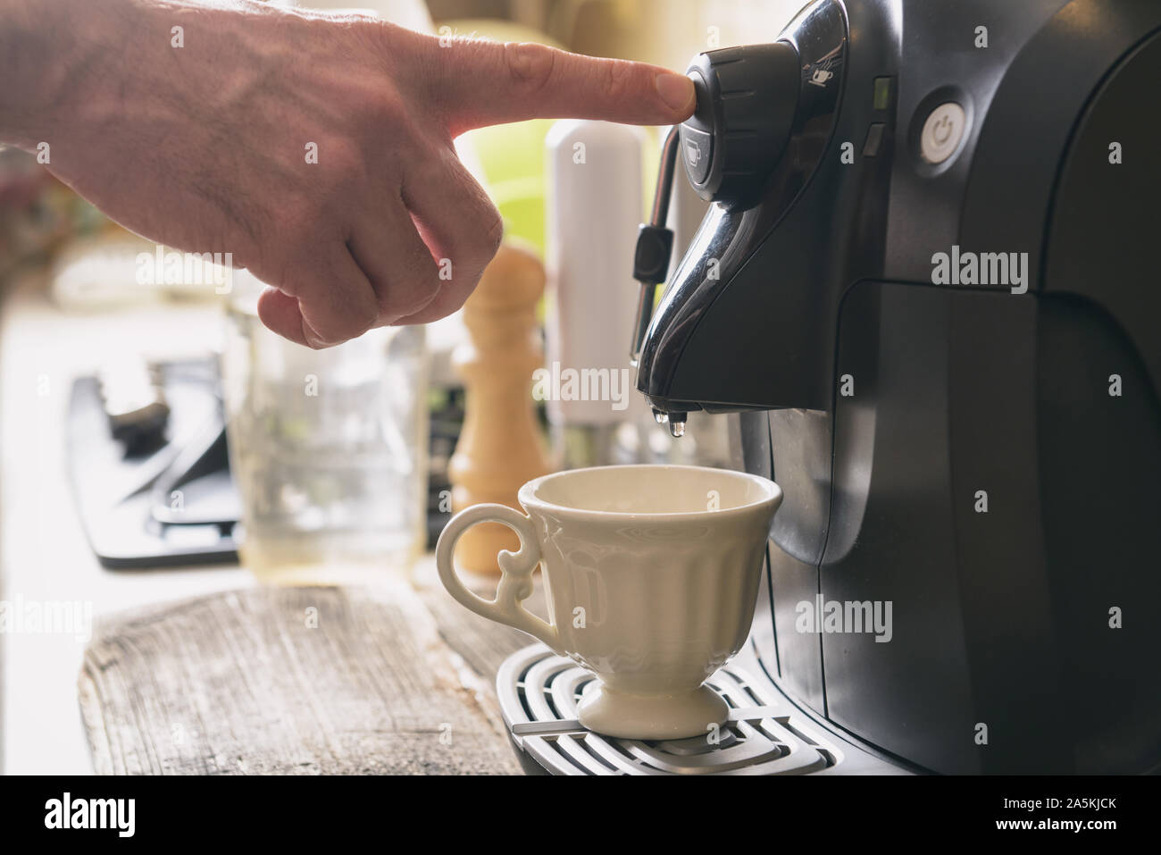 Hand on a coffee machine pressing a button to make a fresh coffee Stock ...