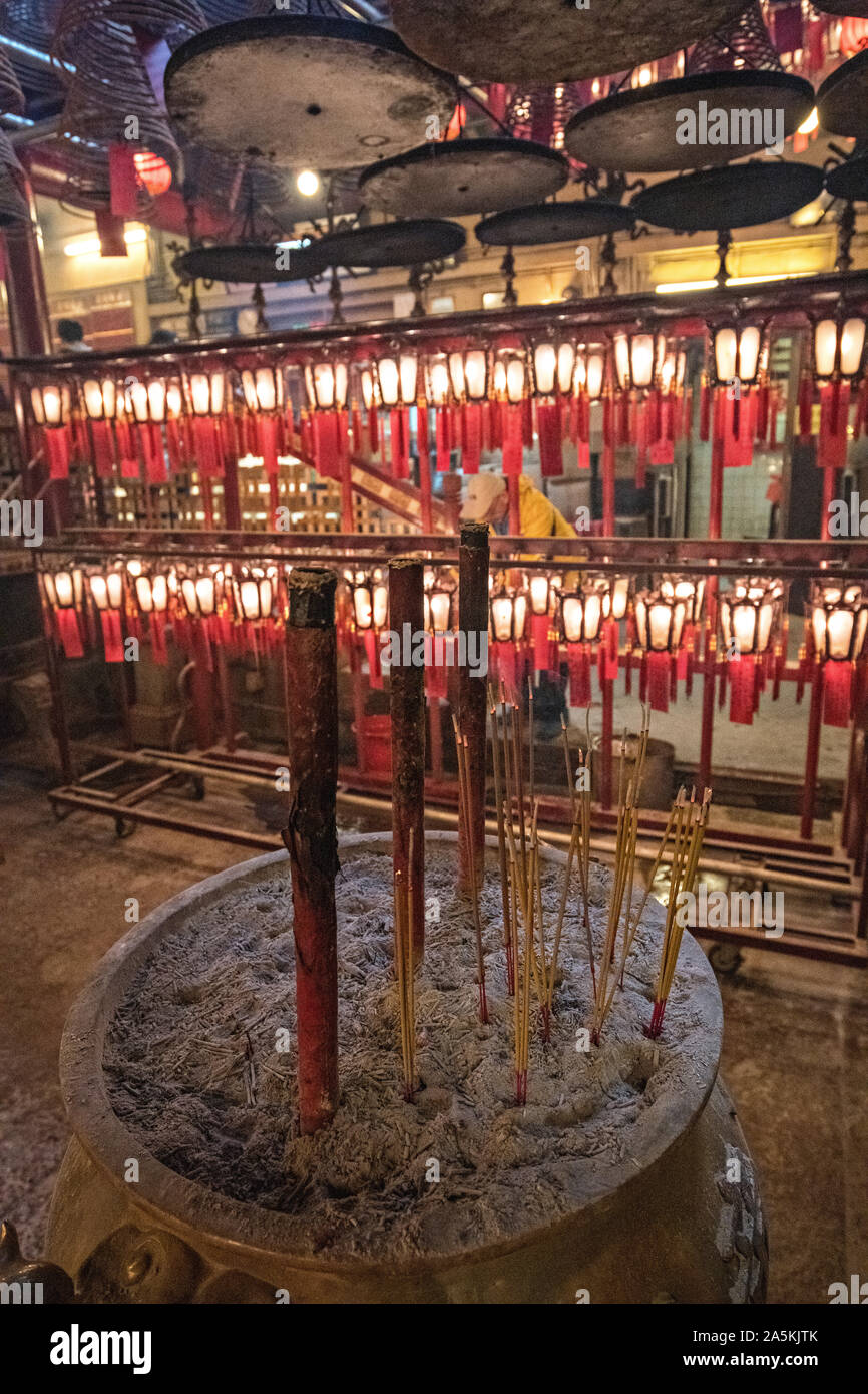 Incense burns inside the Man Mo Temple with giant hanging incense coils ...