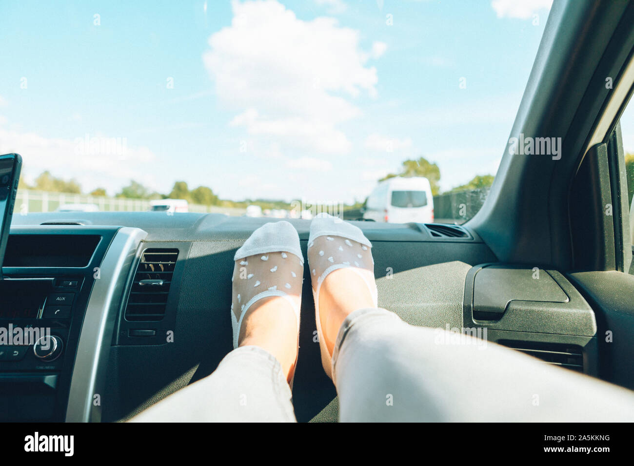 woman legs on car dashboard road trip highway Stock Photo - Alamy